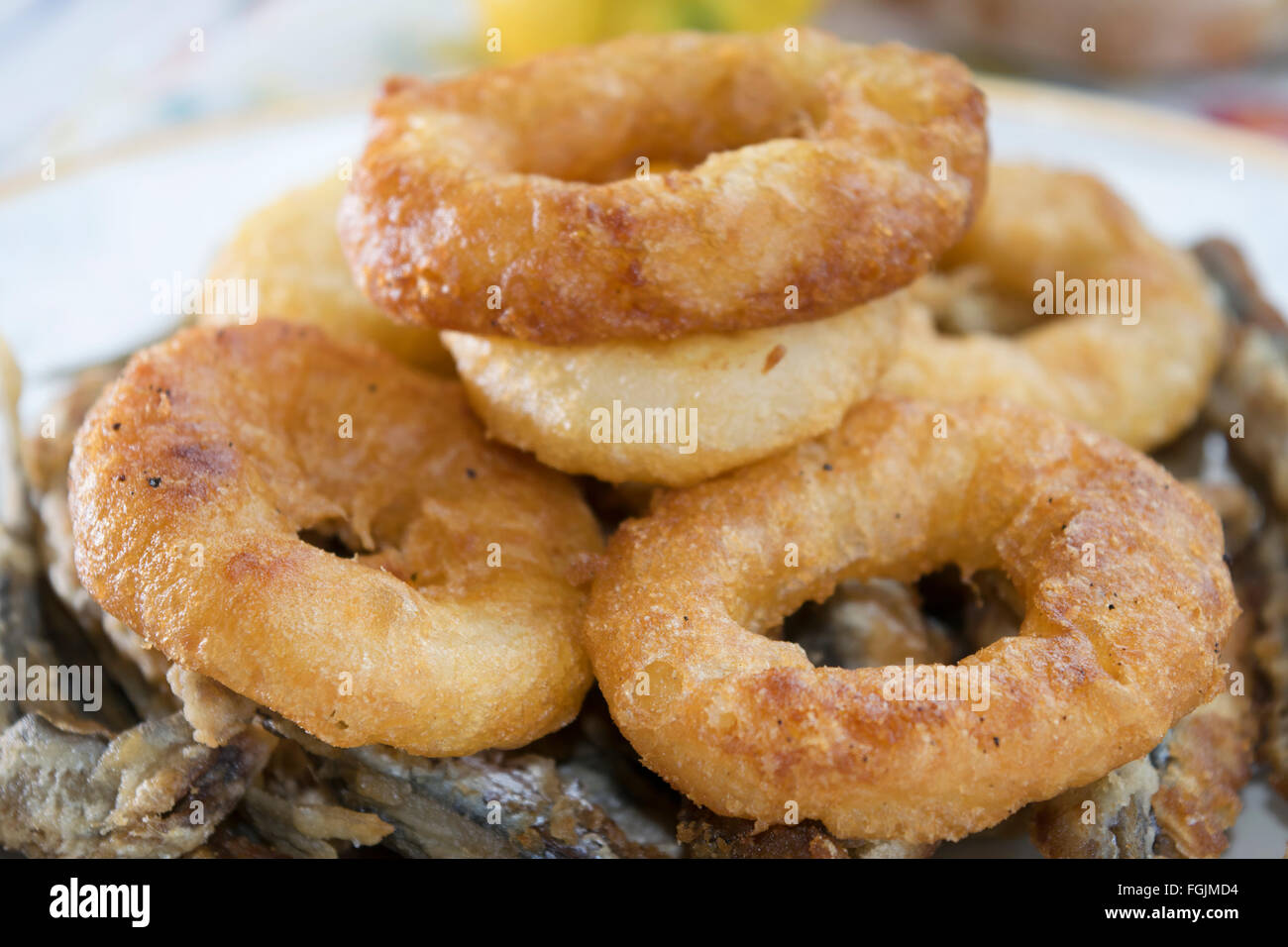 battered and fried rings of squid anchovy fillets Stock Photo - Alamy
