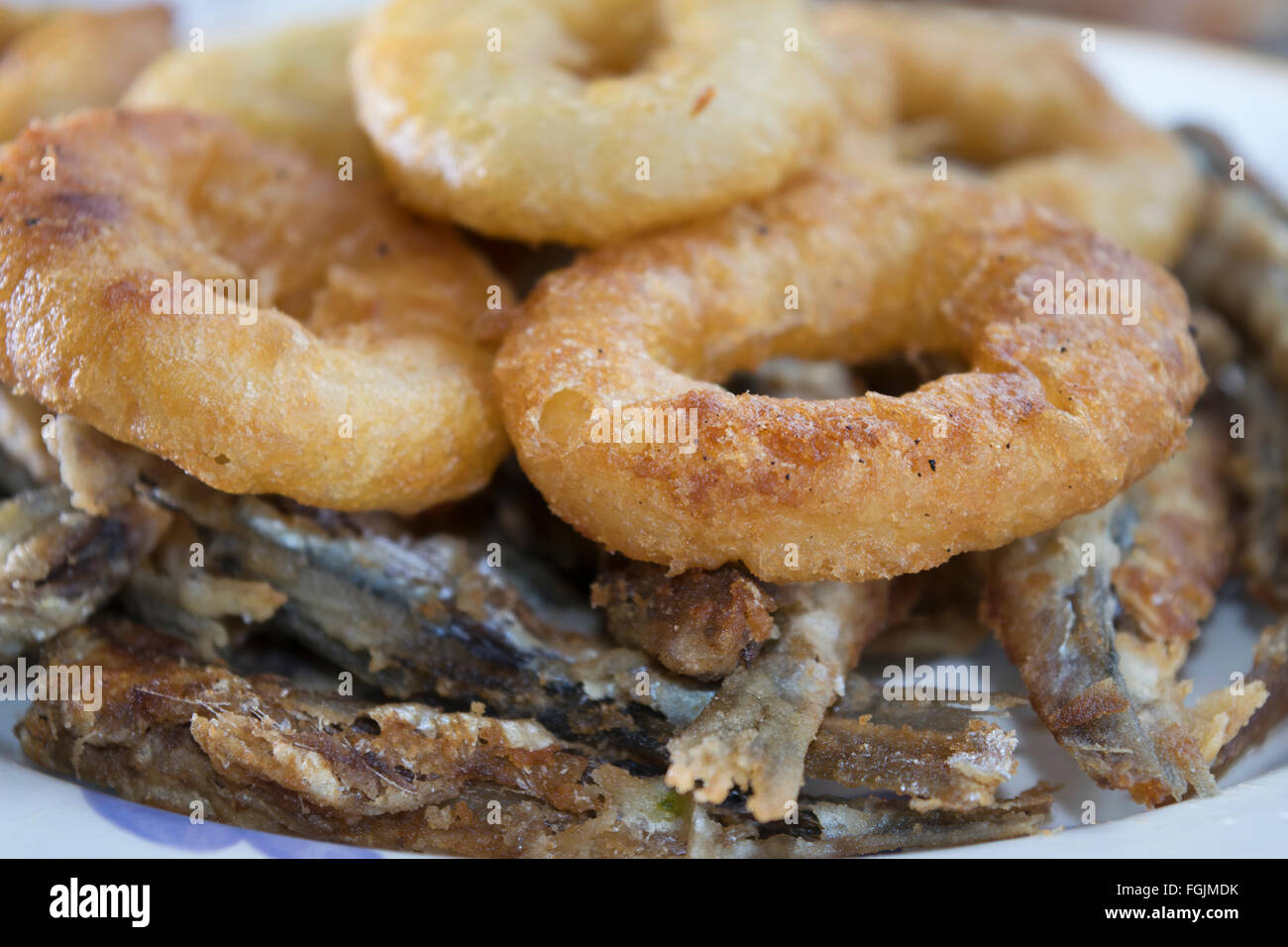battered and fried rings of squid anchovy fillets Stock Photo - Alamy