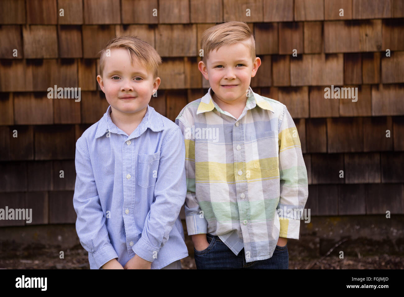 Two brothers together outdoors in a lifestyle portrait with natural ...