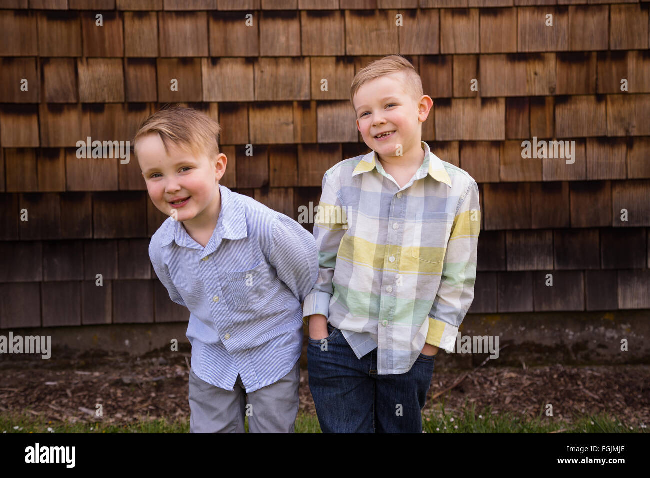 Two brothers together outdoors in a lifestyle portrait with natural ...