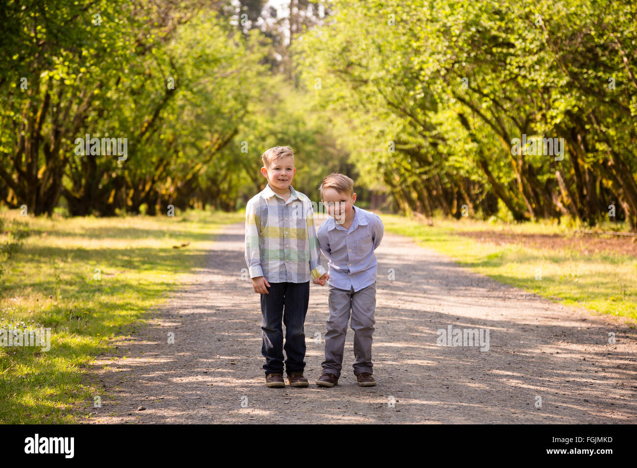 Two brothers together outdoors in a lifestyle portrait with natural ...