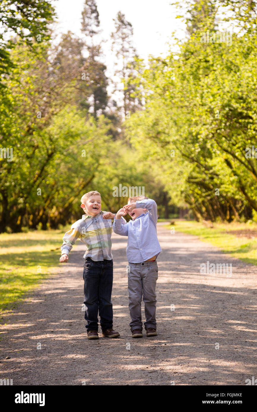 Two brothers together outdoors in a lifestyle portrait with natural ...
