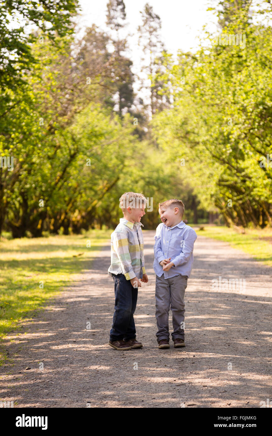 Two brothers together outdoors in a lifestyle portrait with natural ...