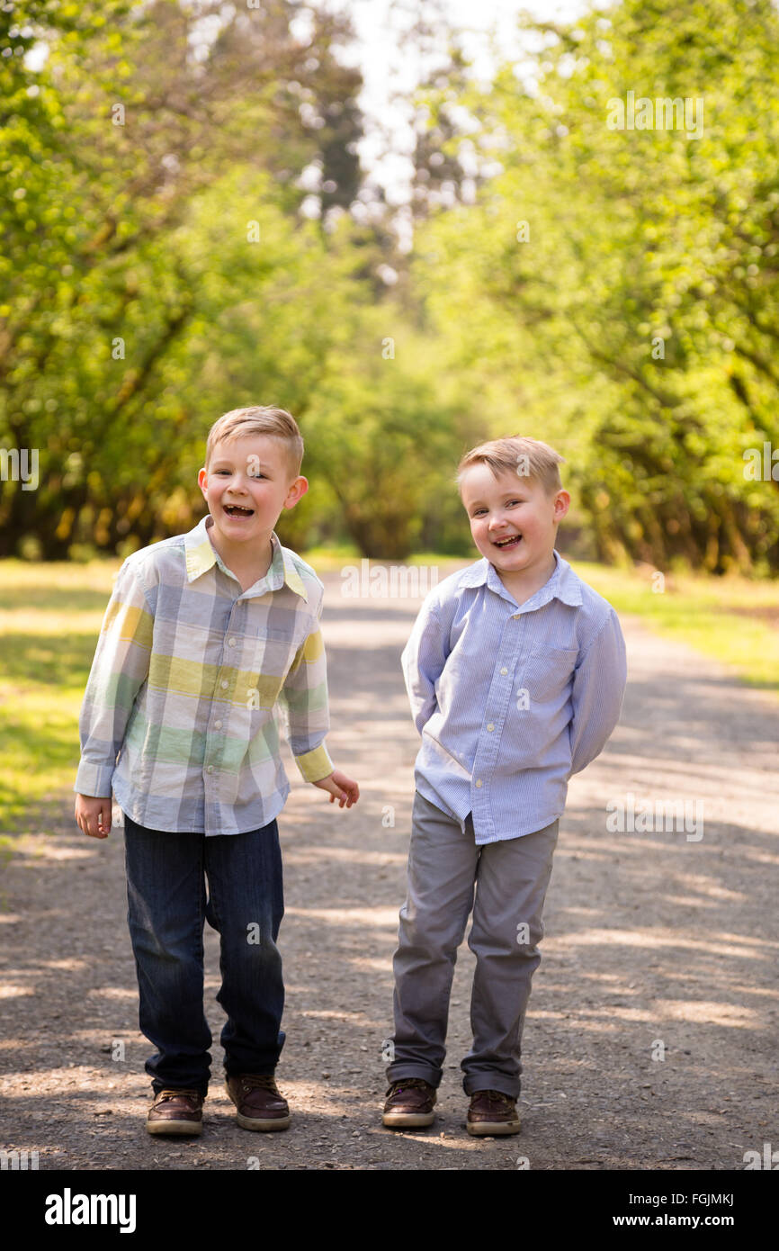 Two brothers together outdoors in a lifestyle portrait with natural ...