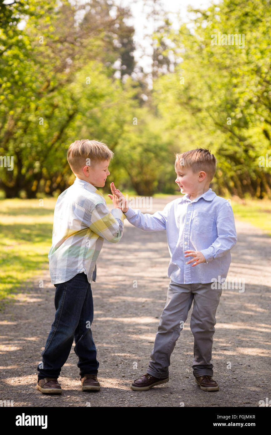 Two brothers together outdoors in a lifestyle portrait with natural ...