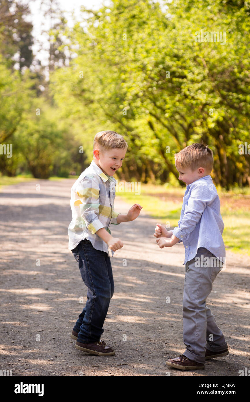 Two brothers together outdoors in a lifestyle portrait with natural ...