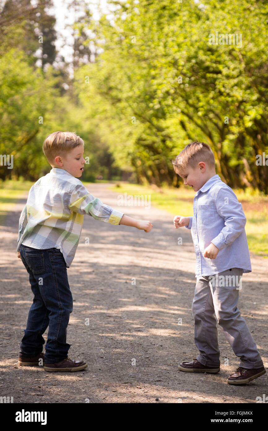 Two brothers together outdoors in a lifestyle portrait with natural ...