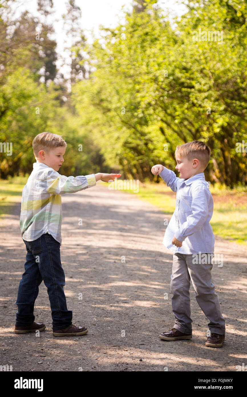 Two brothers together outdoors in a lifestyle portrait with natural ...