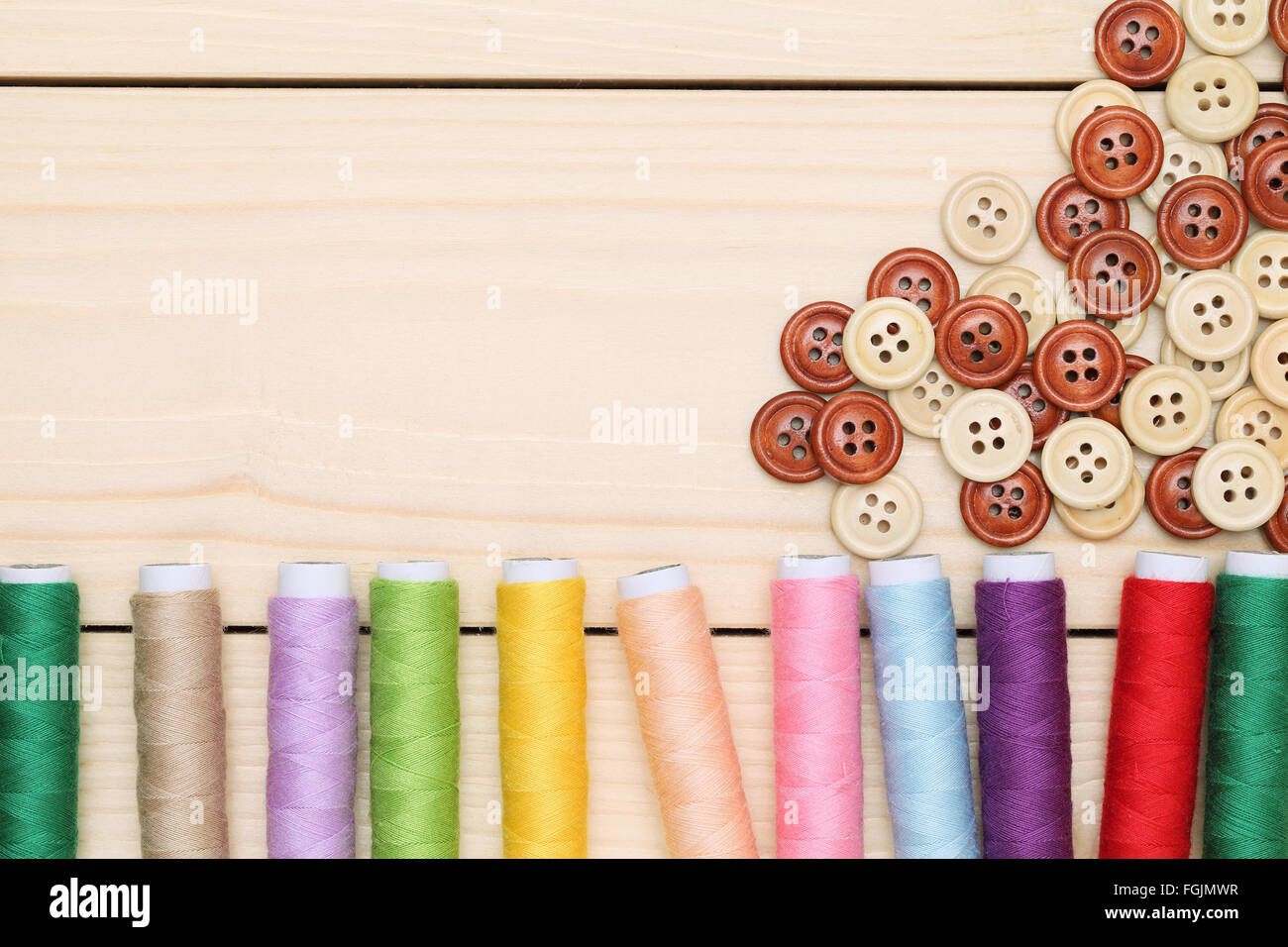 spool of threads and buttons on wooden table background Stock Photo - Alamy