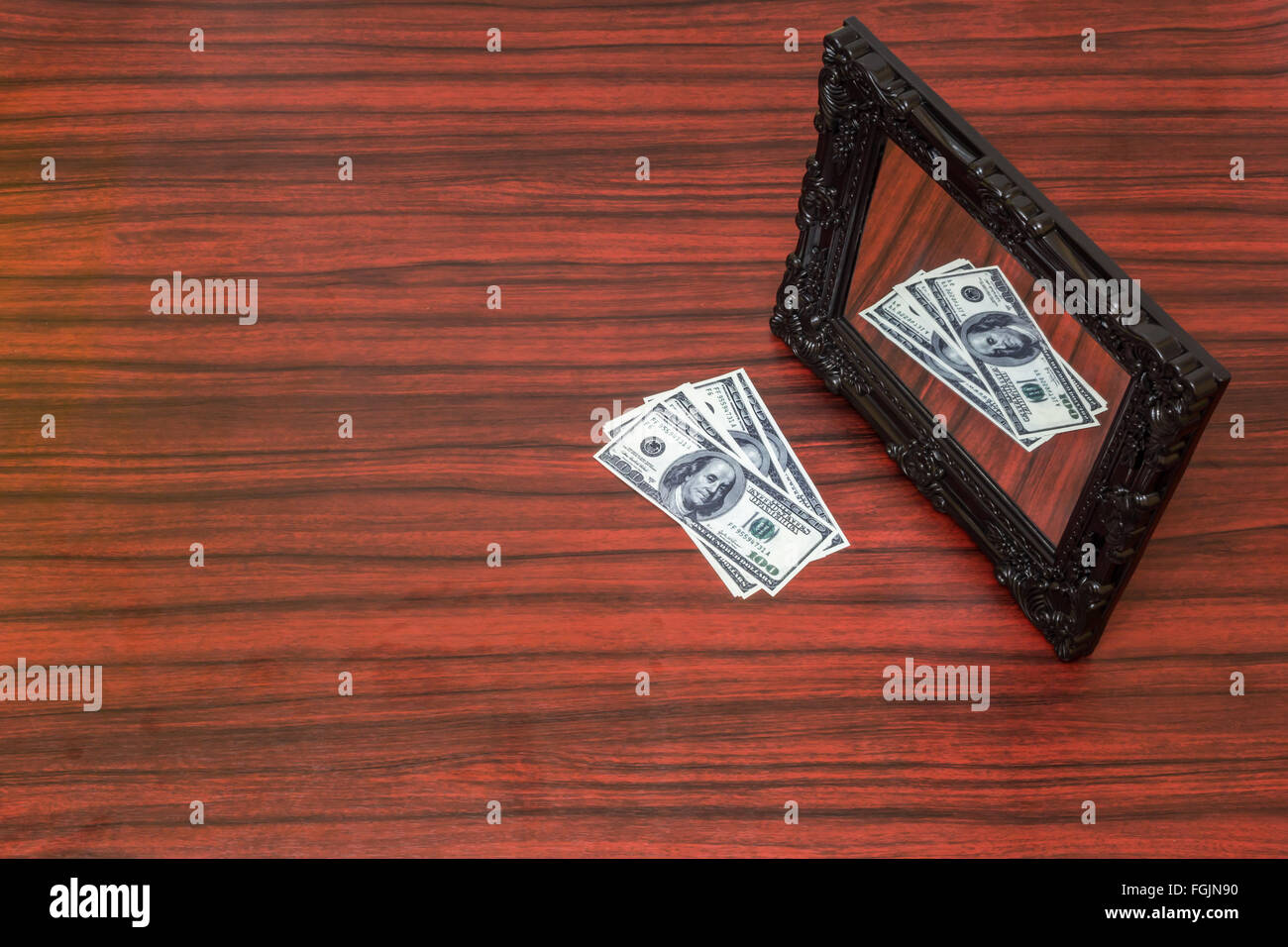 Money on front of a mirror on a desk Stock Photo - Alamy