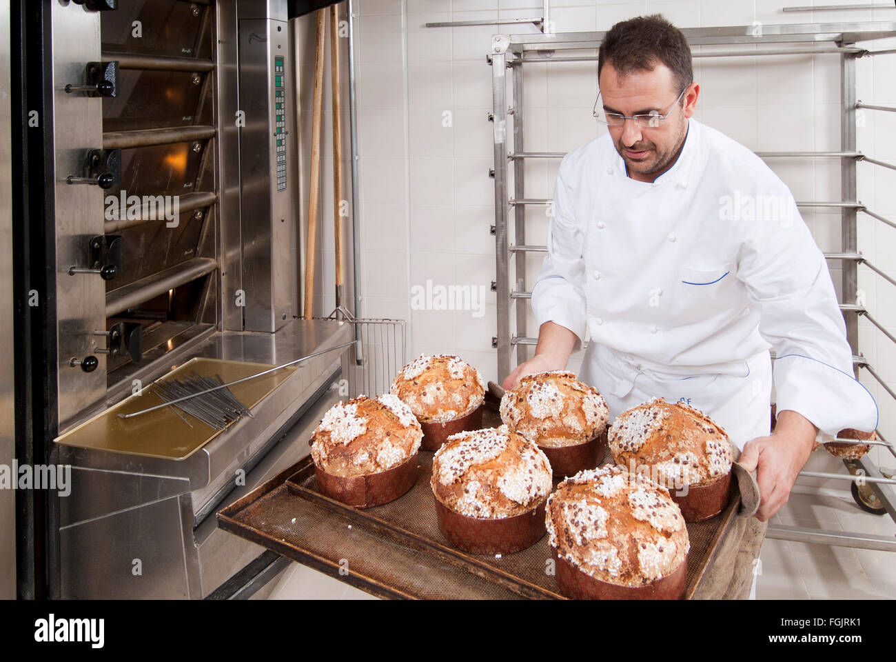 Pastry Chef, takes away the panettone from the oven freshly cooked ...