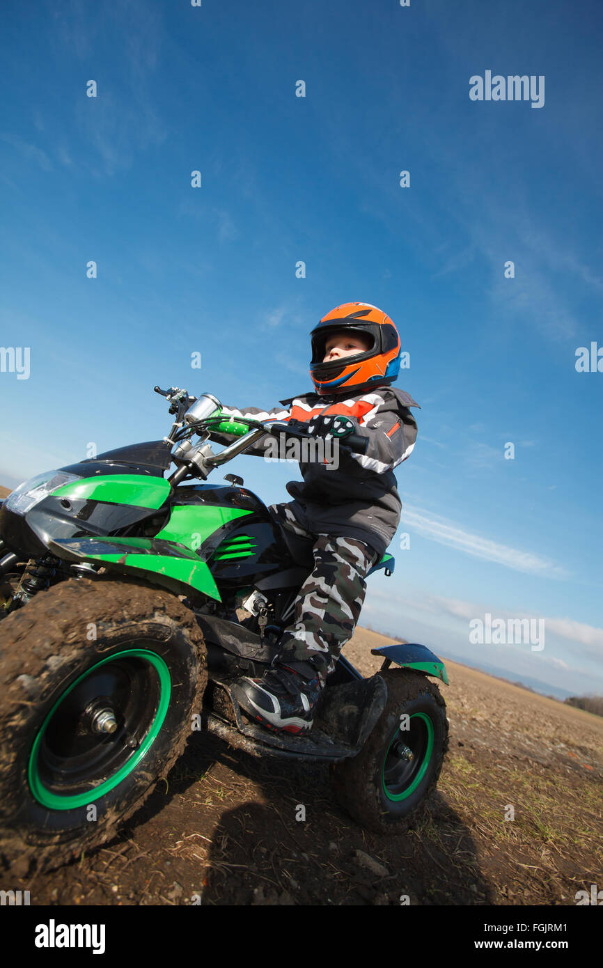 A little boy rides his electric ATV quad Stock Photo - Alamy