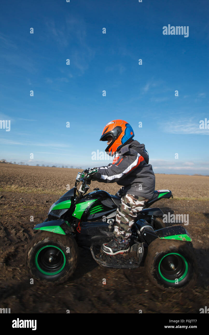 A little boy rides his electric ATV quad Stock Photo - Alamy