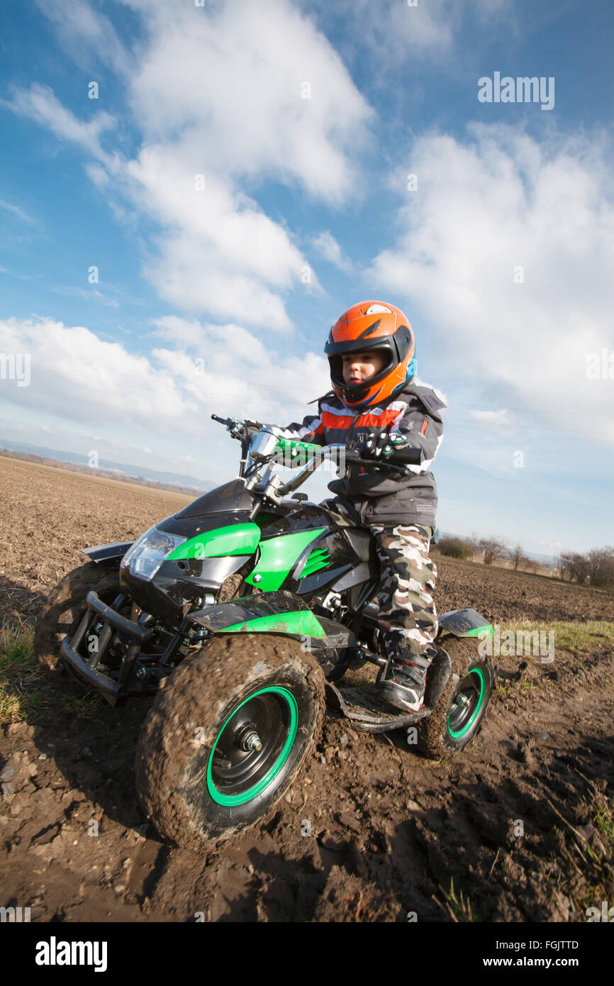 A little boy rides his electric ATV quad Stock Photo - Alamy