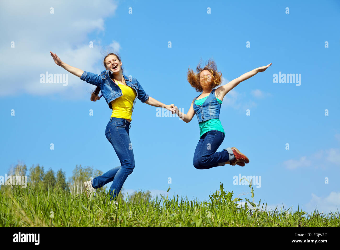 two young women jumping Stock Photo - Alamy