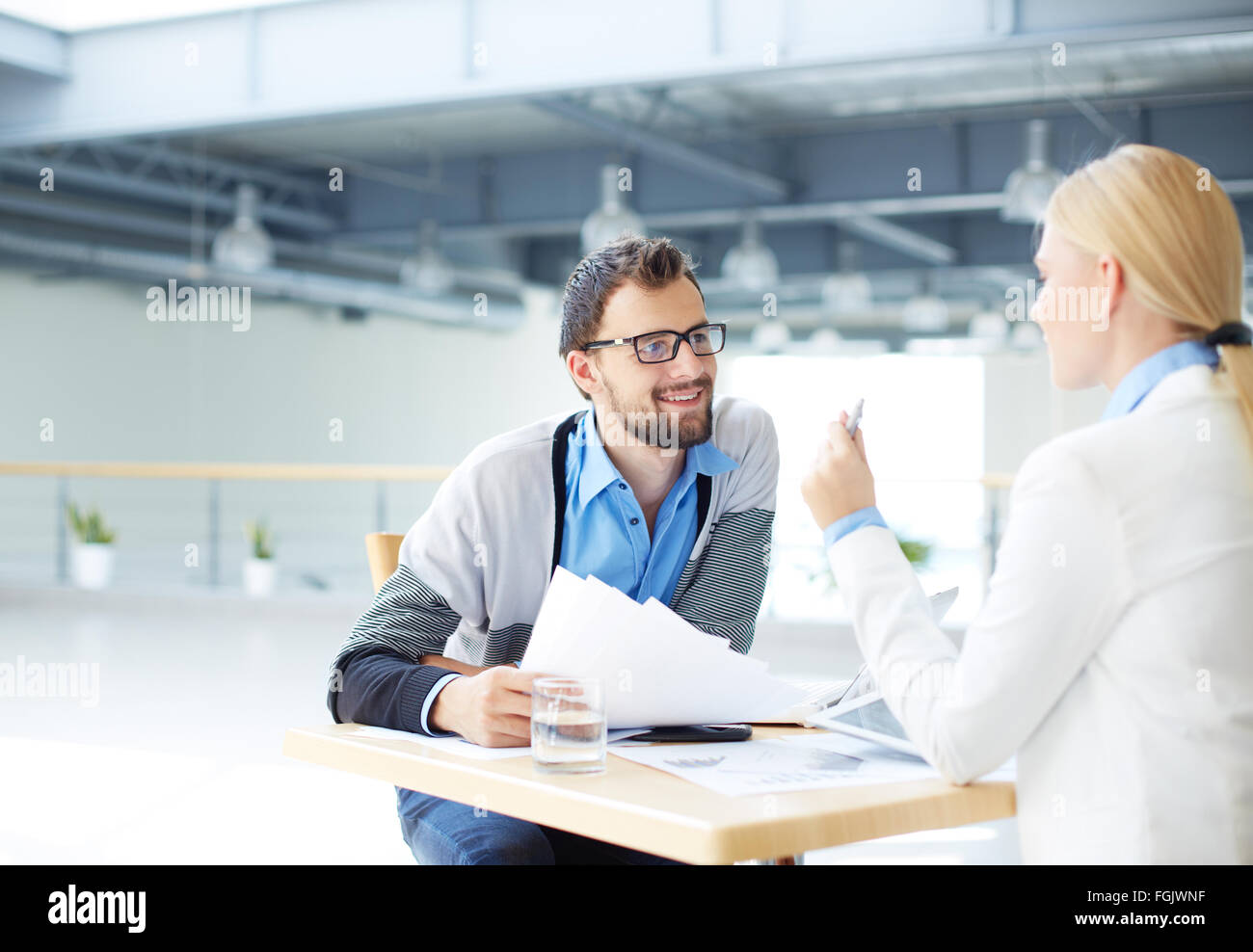 Two co-workers discussing plans and papers at meeting Stock Photo - Alamy