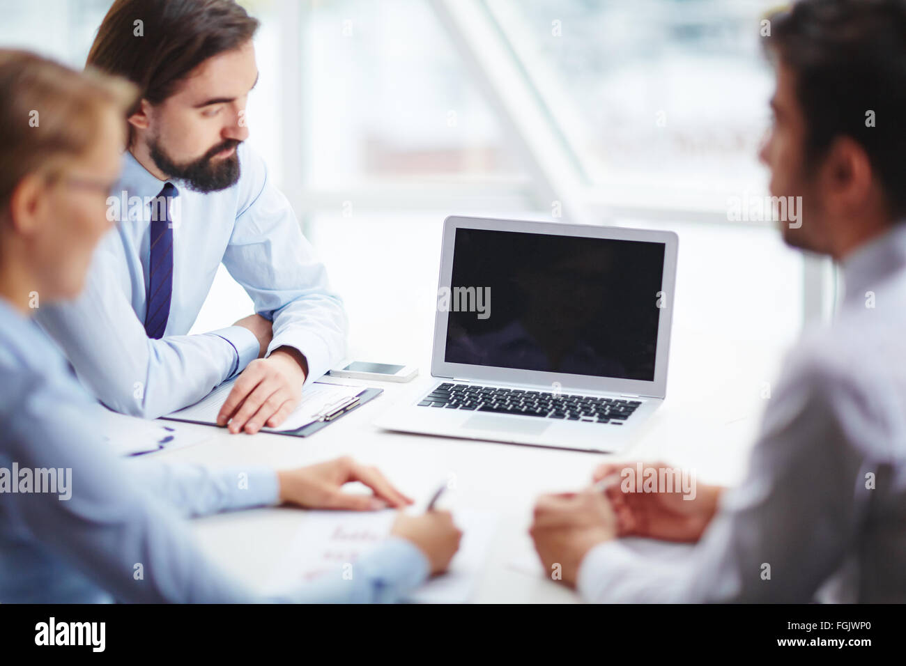Young managers looking at laptop screen Stock Photo - Alamy