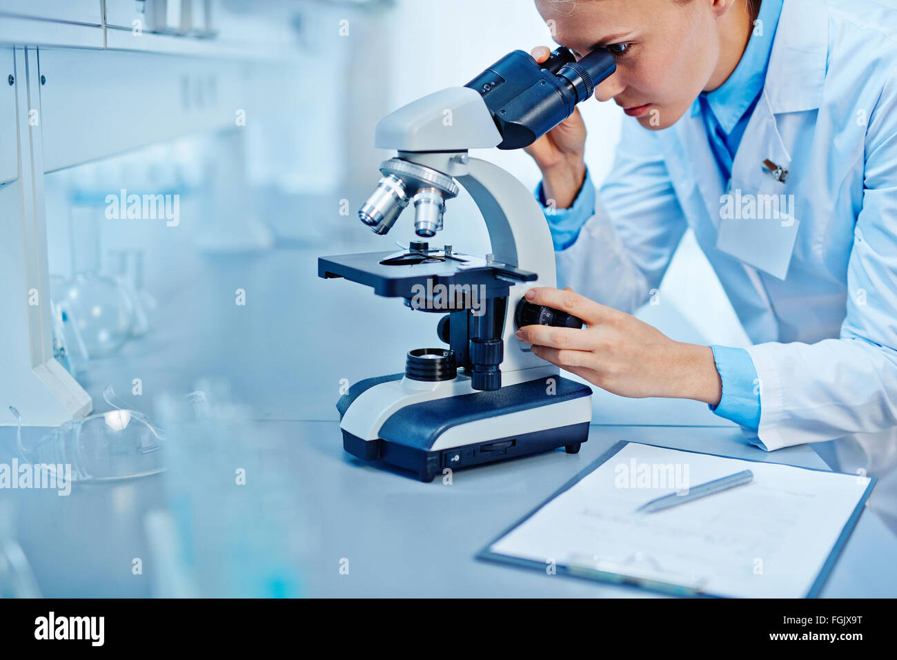 Young scientist studying new virus in microscope Stock Photo - Alamy