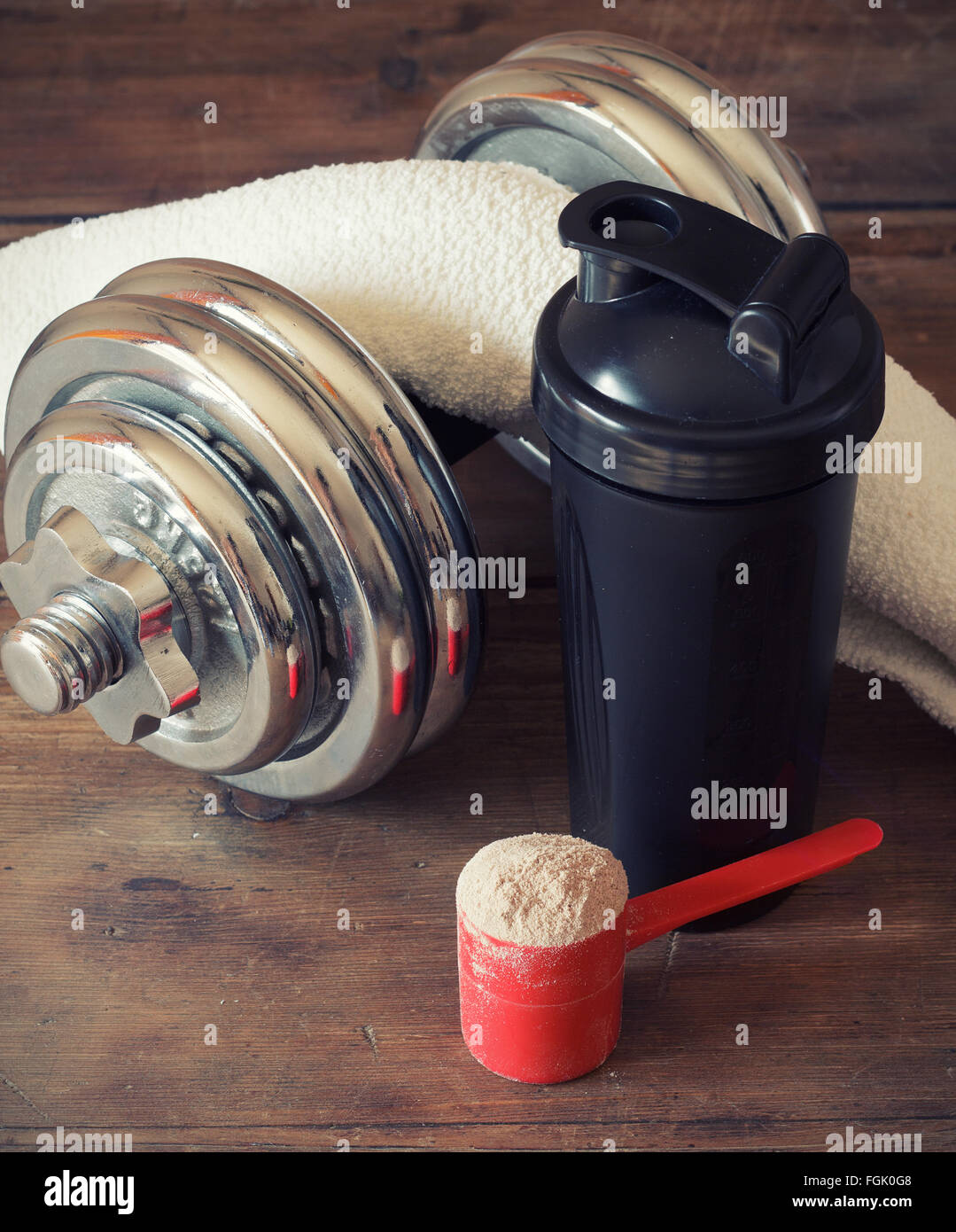 Whey protein powder in scoop with vitamins and plastic shaker on wooden ...