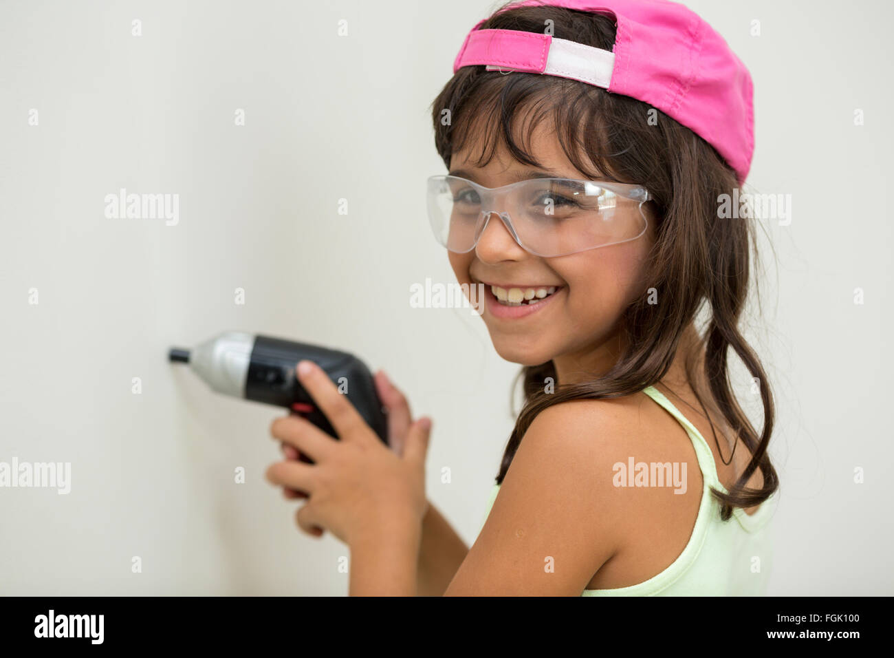 Young girl using screwdriver and cap Stock Photo - Alamy