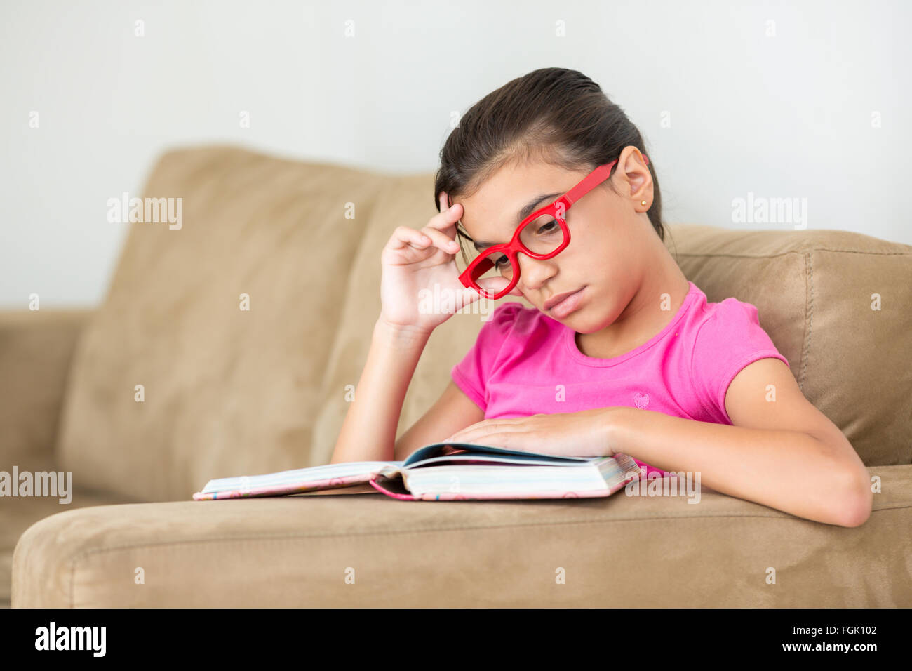 Young girl reading bored, with glasses Stock Photo - Alamy