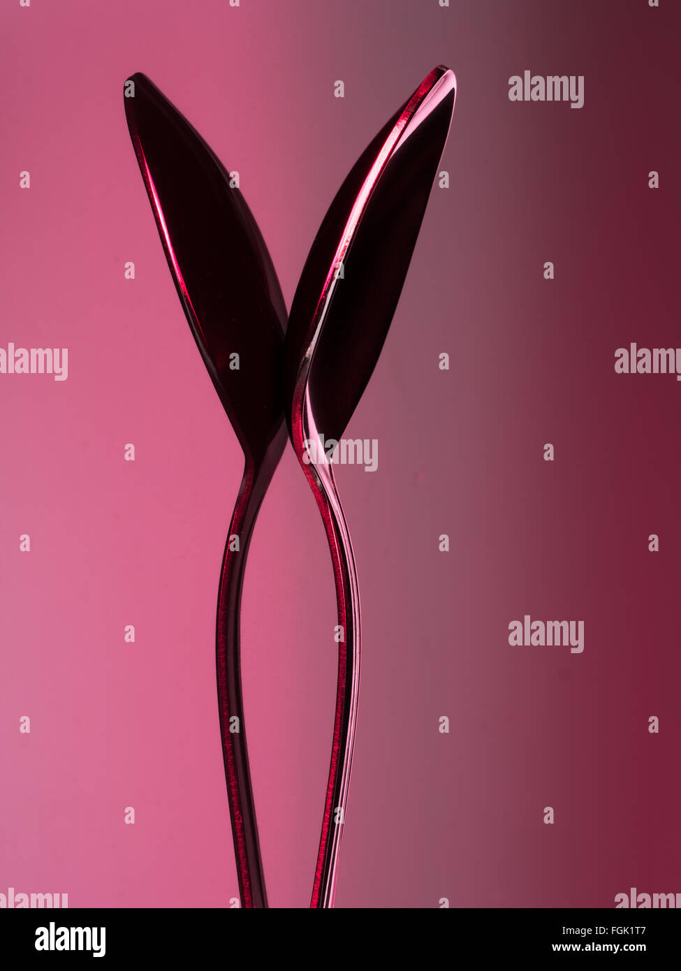 Pink spoon, reflected, abstract food or eating background. Red light ...