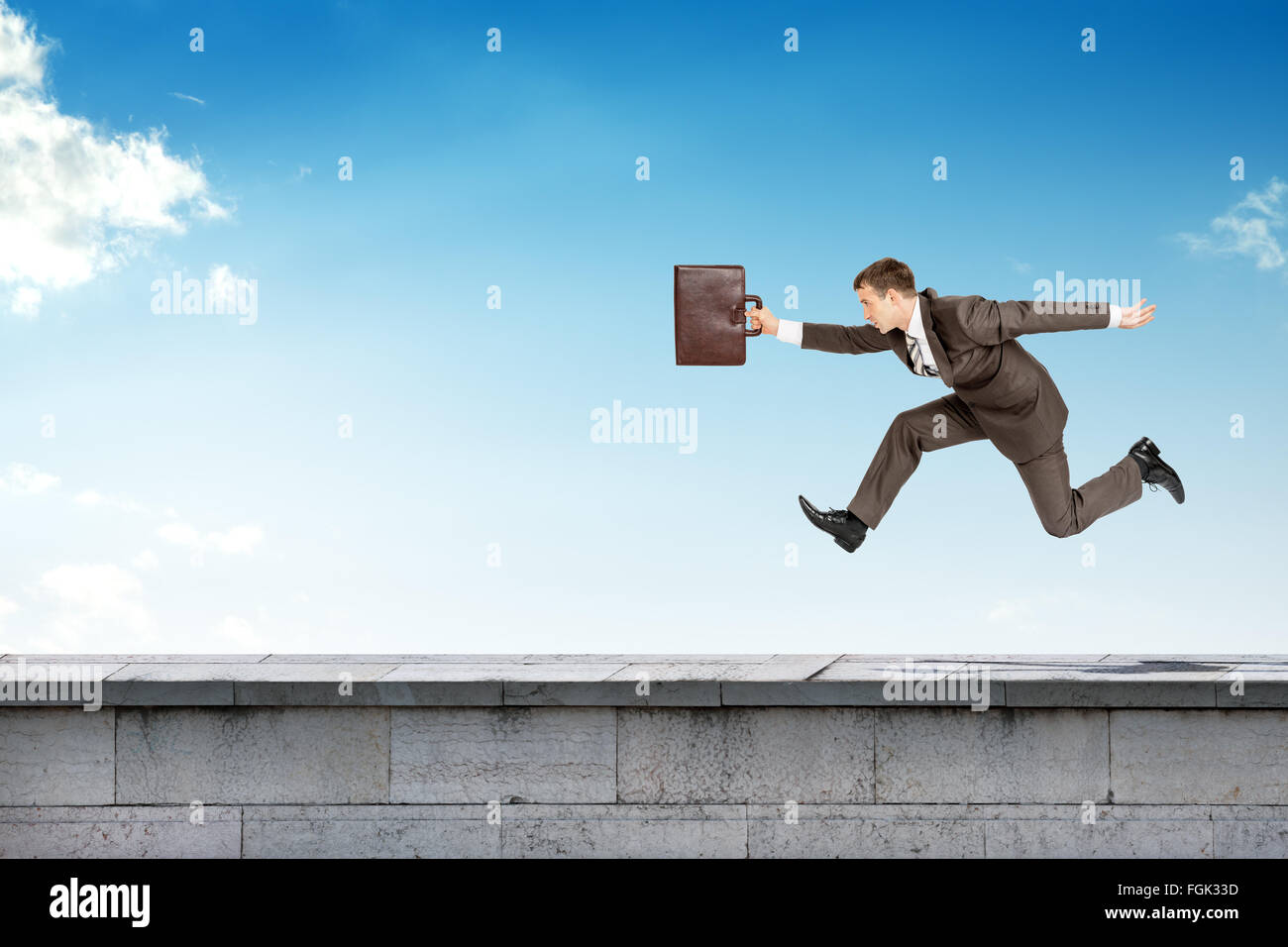 Businessman running on building roof Stock Photo - Alamy