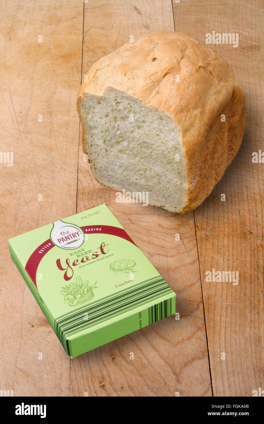 Home baked loaf of bread with a carton of powdered baking yeast sachets ...