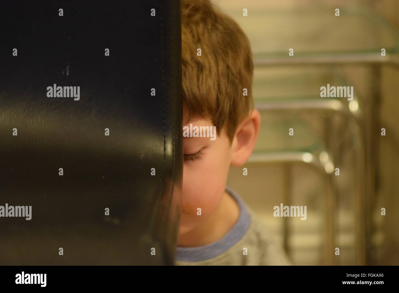 boy hiding behind chair Stock Photo - Alamy