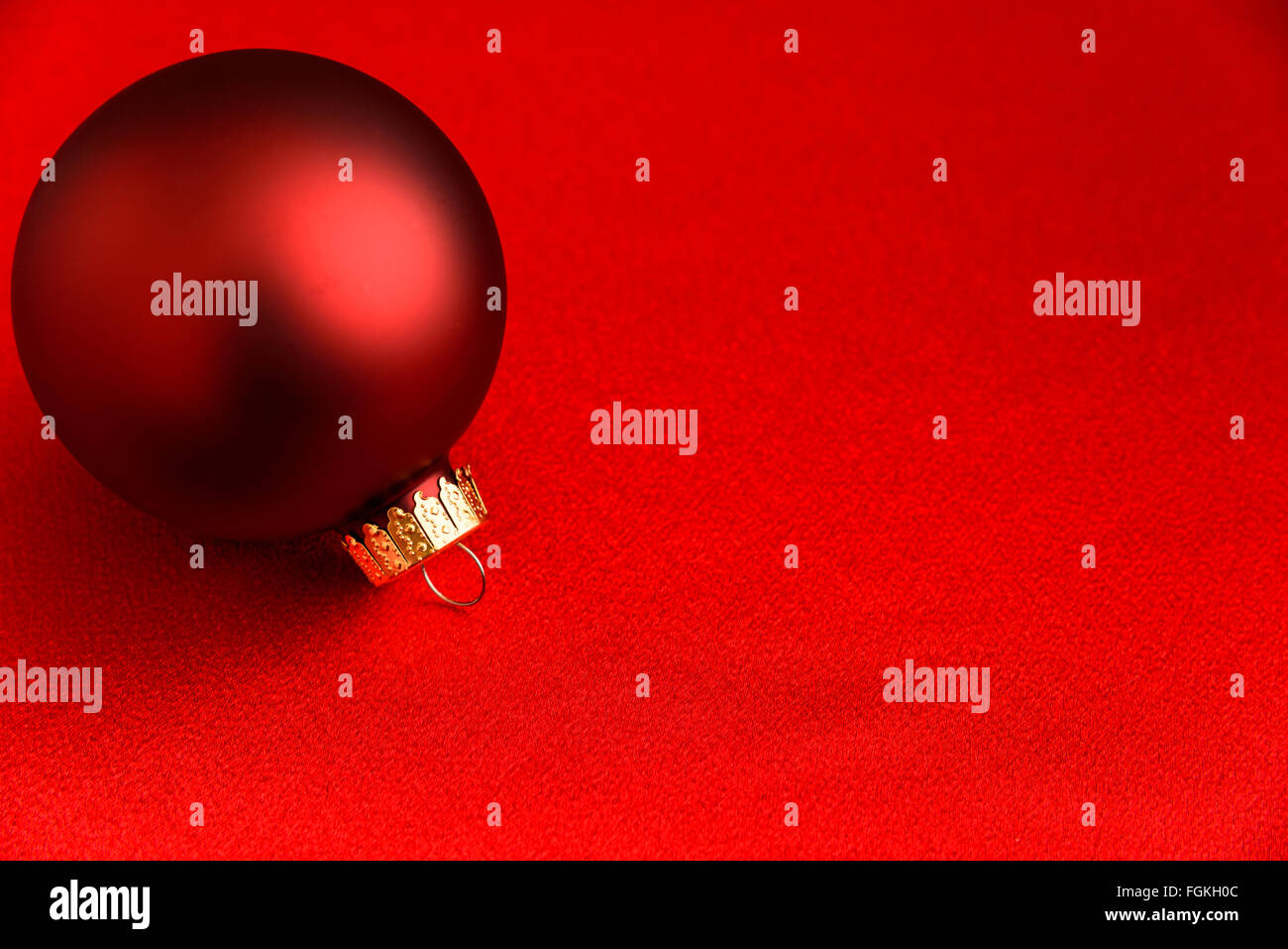 Single red satin glass Christmas bulb on a red luxurious background ...