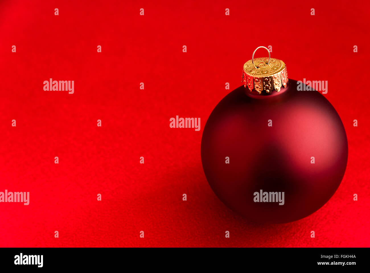 Single red satin glass Christmas bulb on a red luxurious background ...