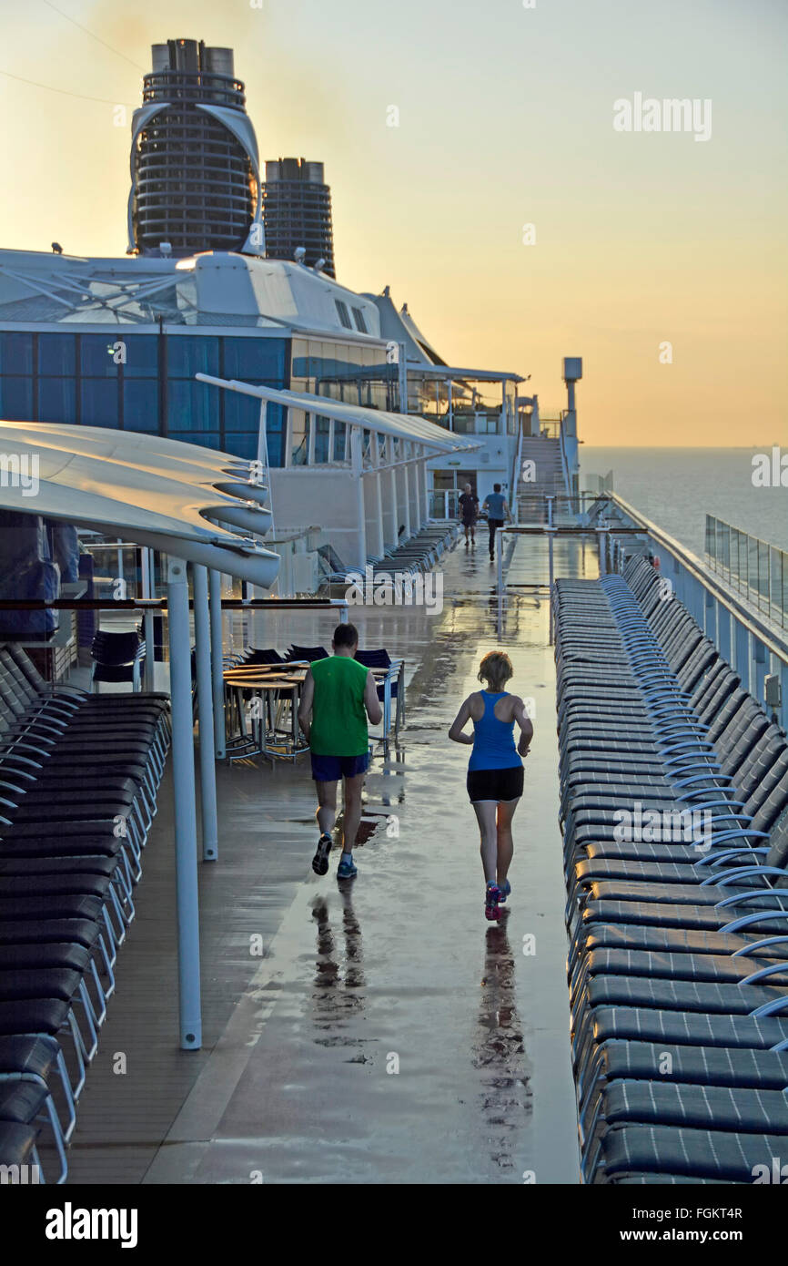Cruise ship liner deck early morning joggers running with care along ...