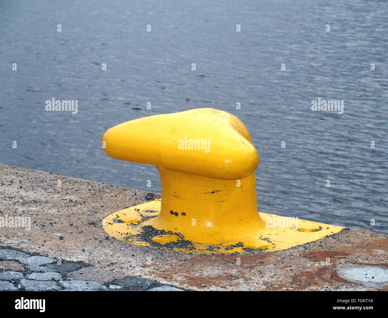 Yellow bollard on a quay Stock Photo - Alamy