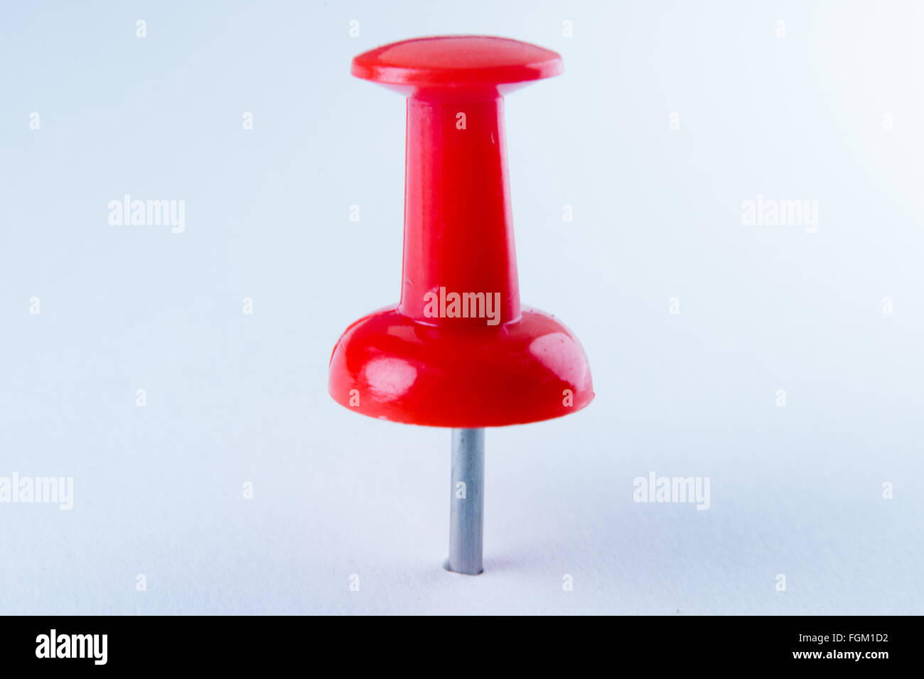 Red paper pin pinned into paper Stock Photo - Alamy