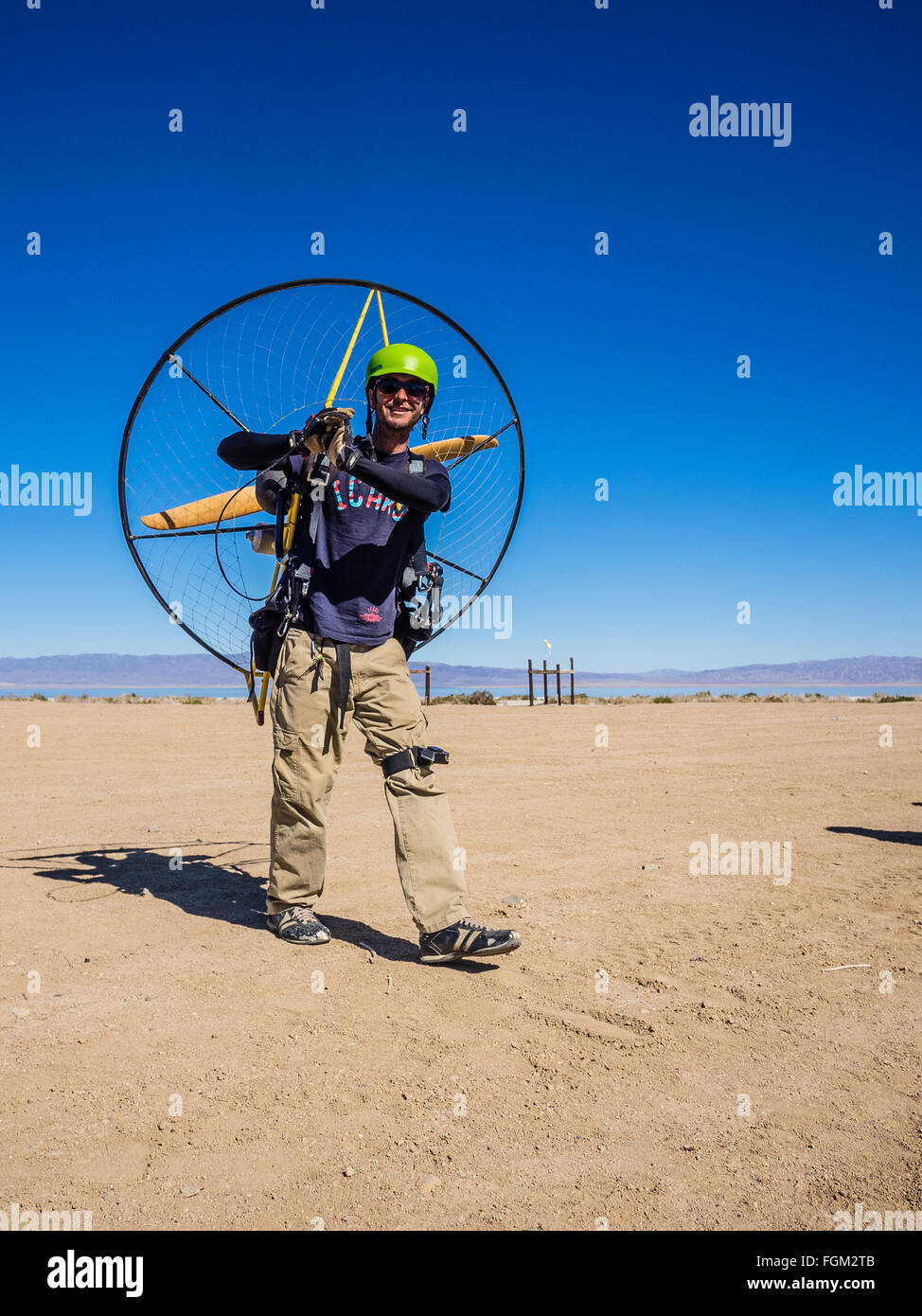 Paramotoring pilot lands his paramotor and starts to undo his harness ...