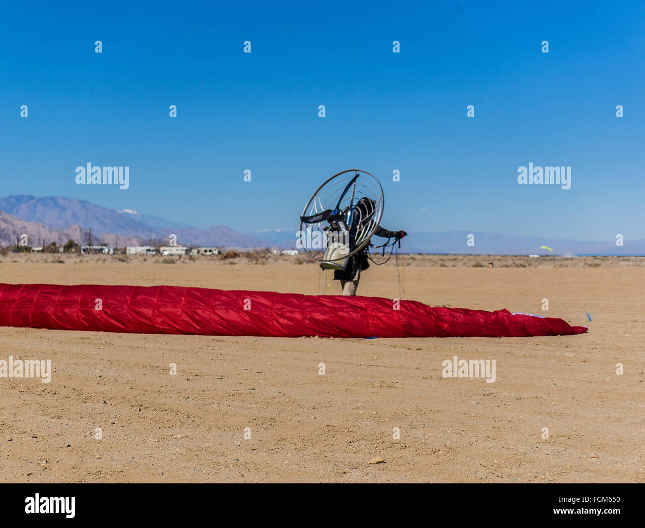 A paramotoring pilot gets ready for takeoff in his paramotor at a ...