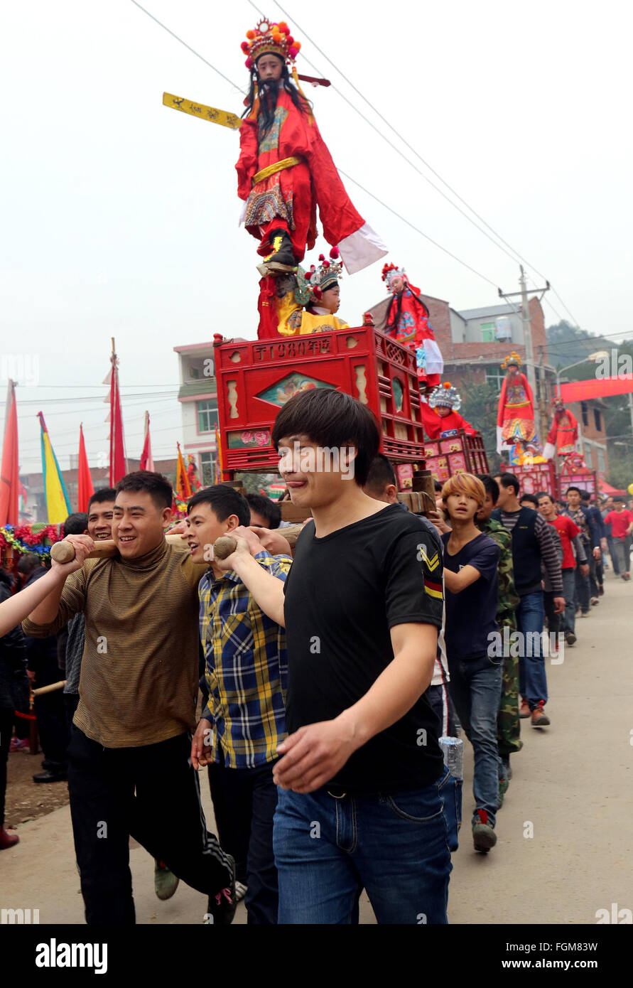 Liancheng. 21st Feb, 2016. People carrying sedan chairs take part in a ...