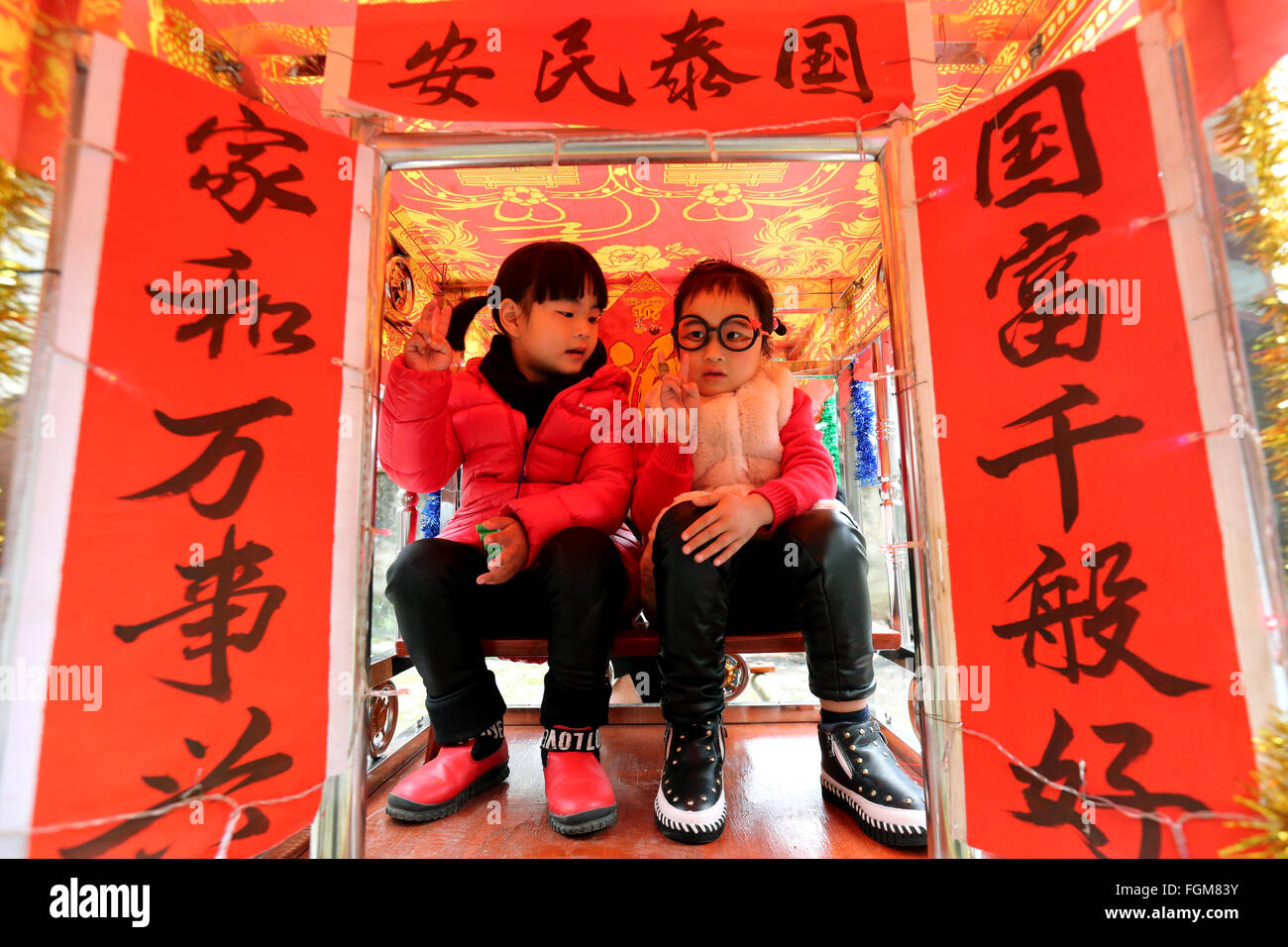 Liancheng. 21st Feb, 2016. Two girls sit in a sedan chair during a ...