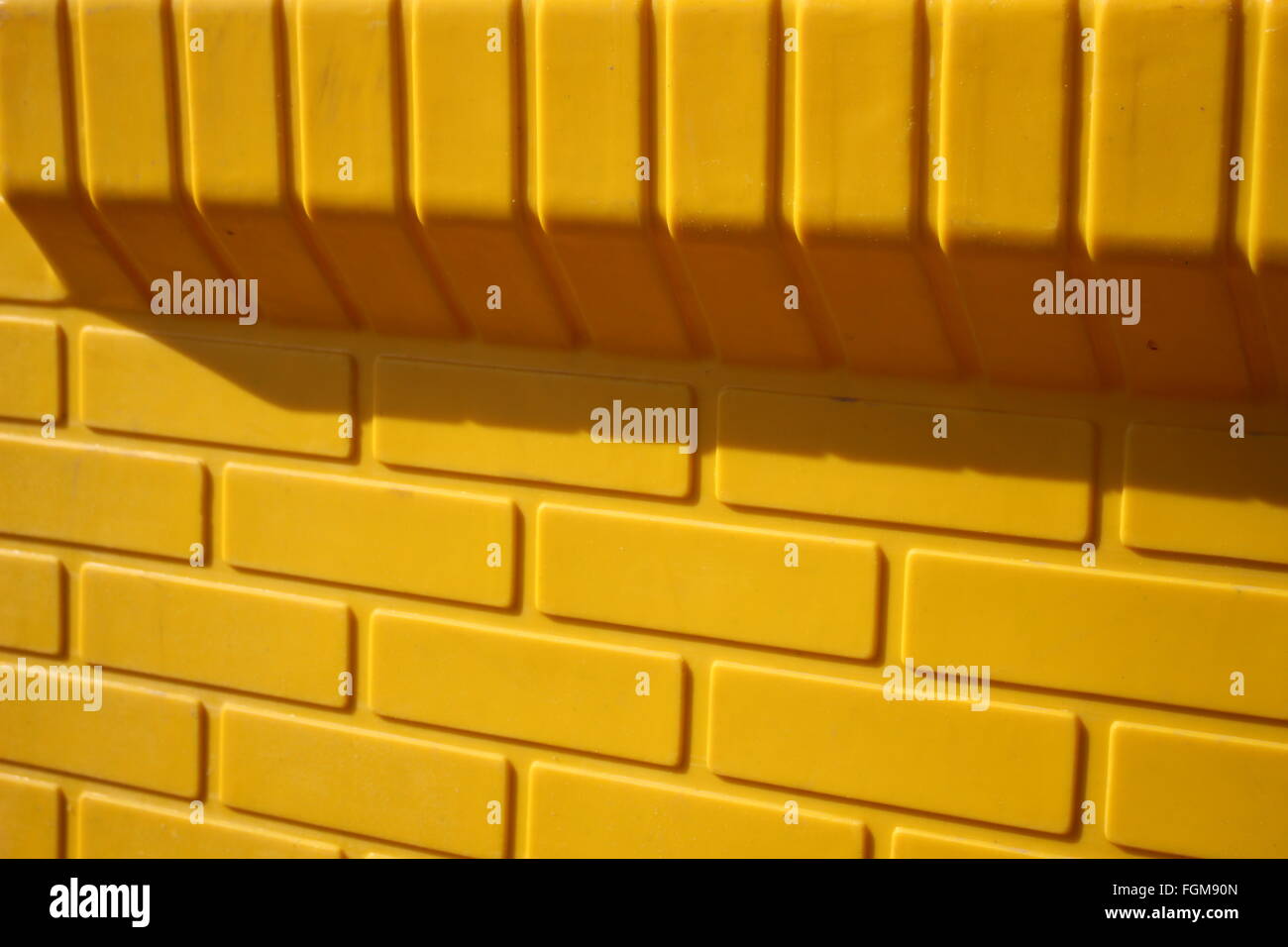 Yellow brick wall on playground Stock Photo - Alamy