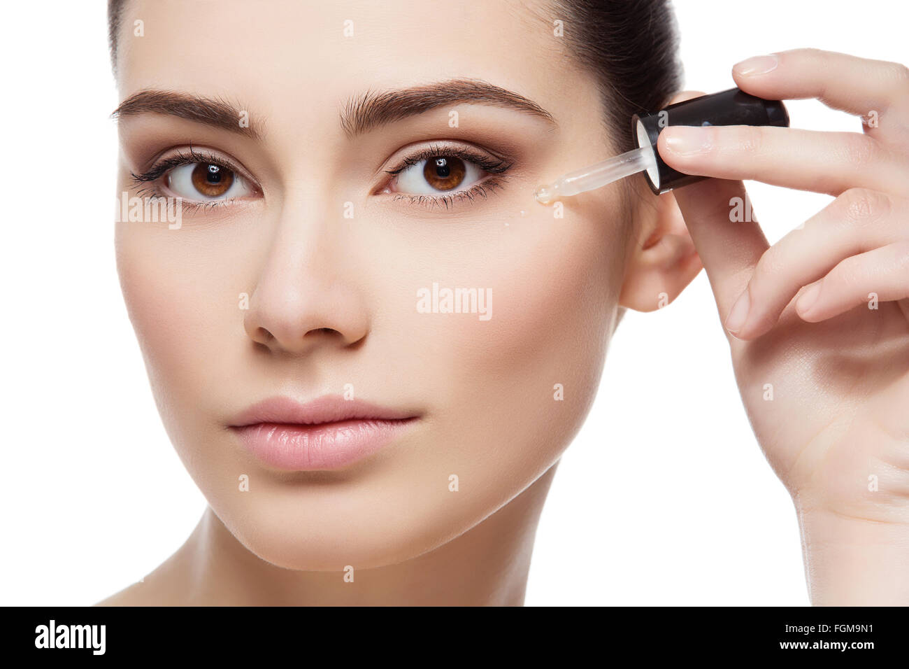 Girl applying eye serum Stock Photo - Alamy