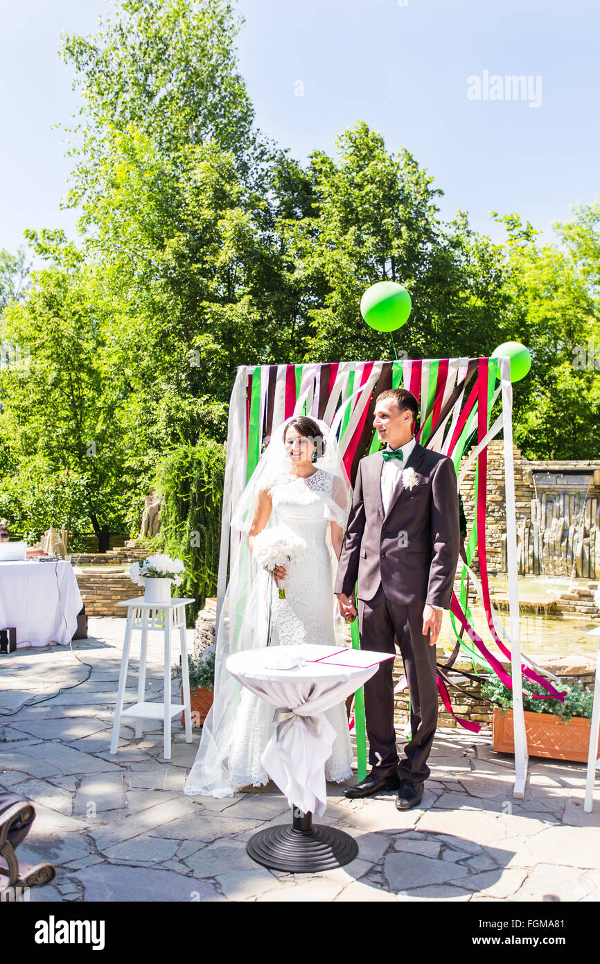 newly married couple under wedding arch Stock Photo - Alamy