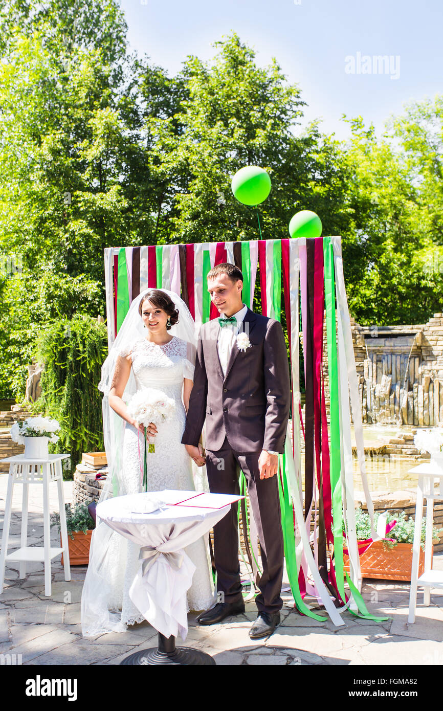 newly married couple under wedding arch Stock Photo - Alamy