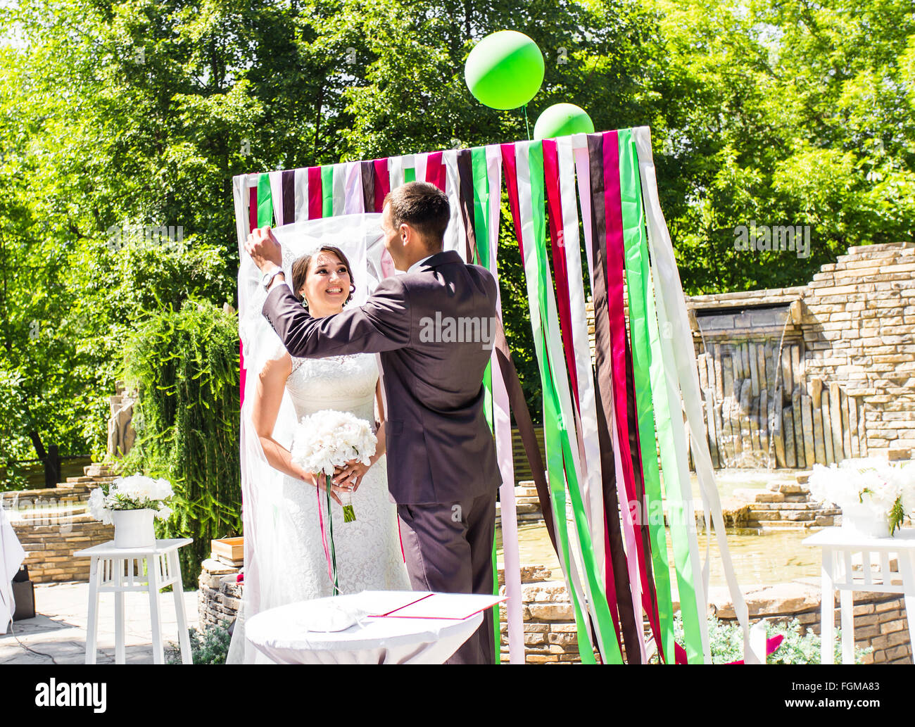 newly married couple under wedding arch Stock Photo - Alamy