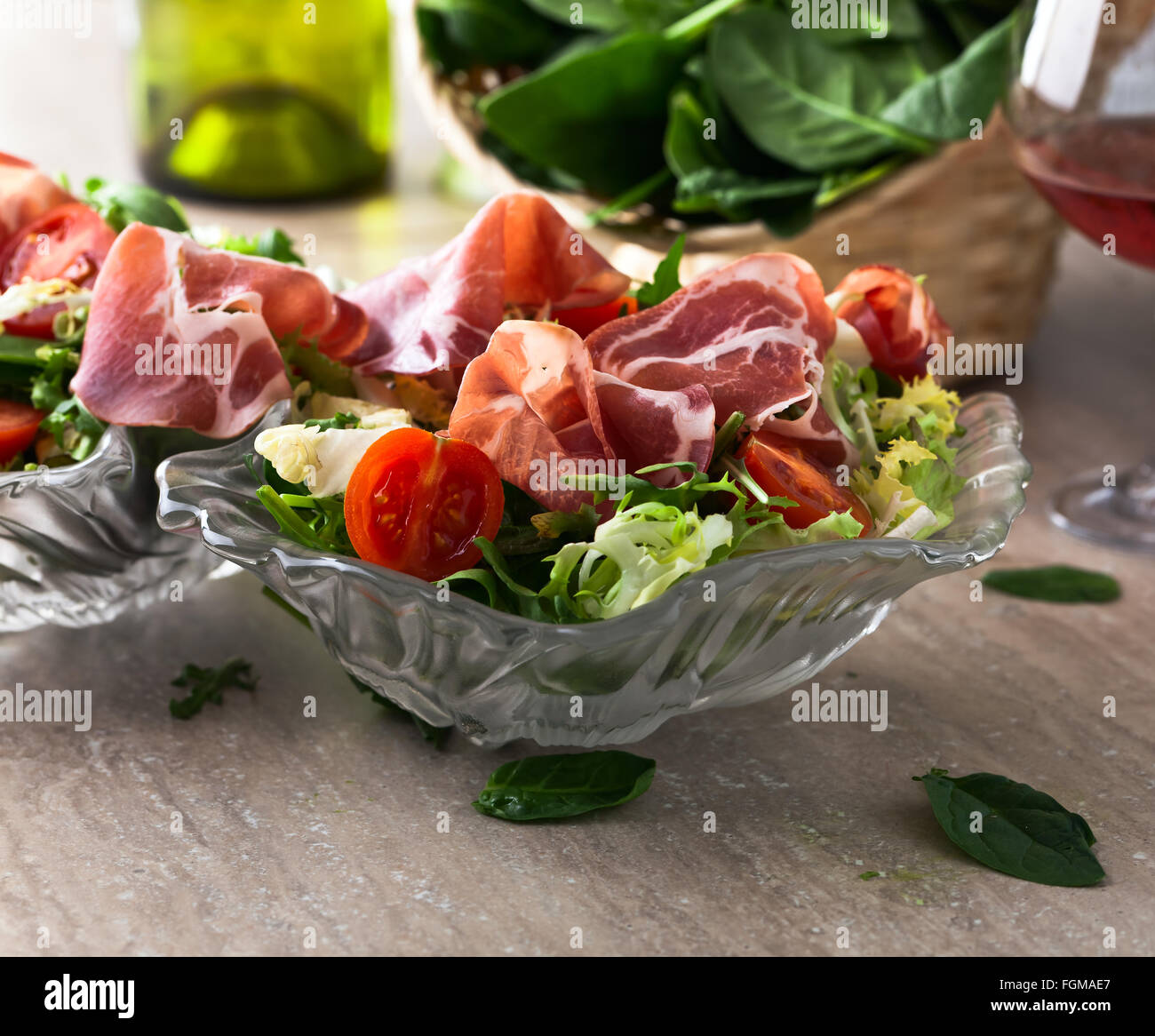 green salad with jamon on a kitchen table Stock Photo - Alamy