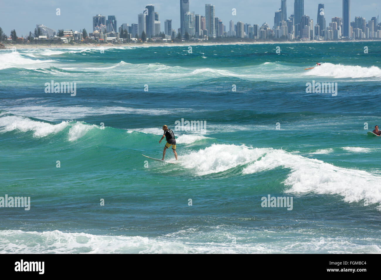 man surfing in the ocean at Burleigh Heads with Surfers Paradise in the ...