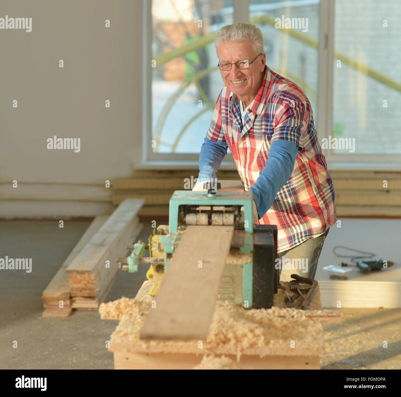 Senior man repairing in the room Stock Photo - Alamy