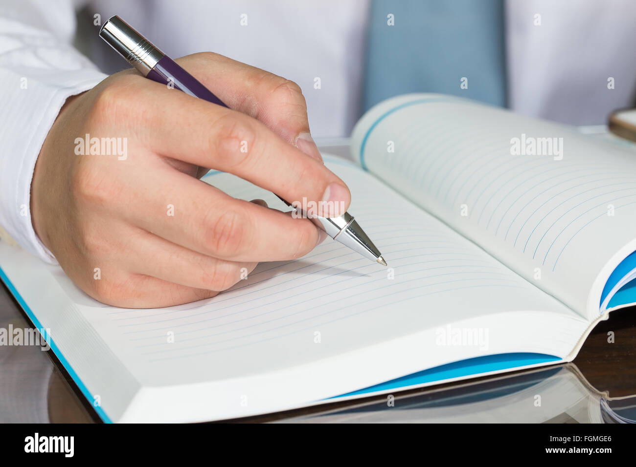 Businessman makes a note in notebook Stock Photo - Alamy