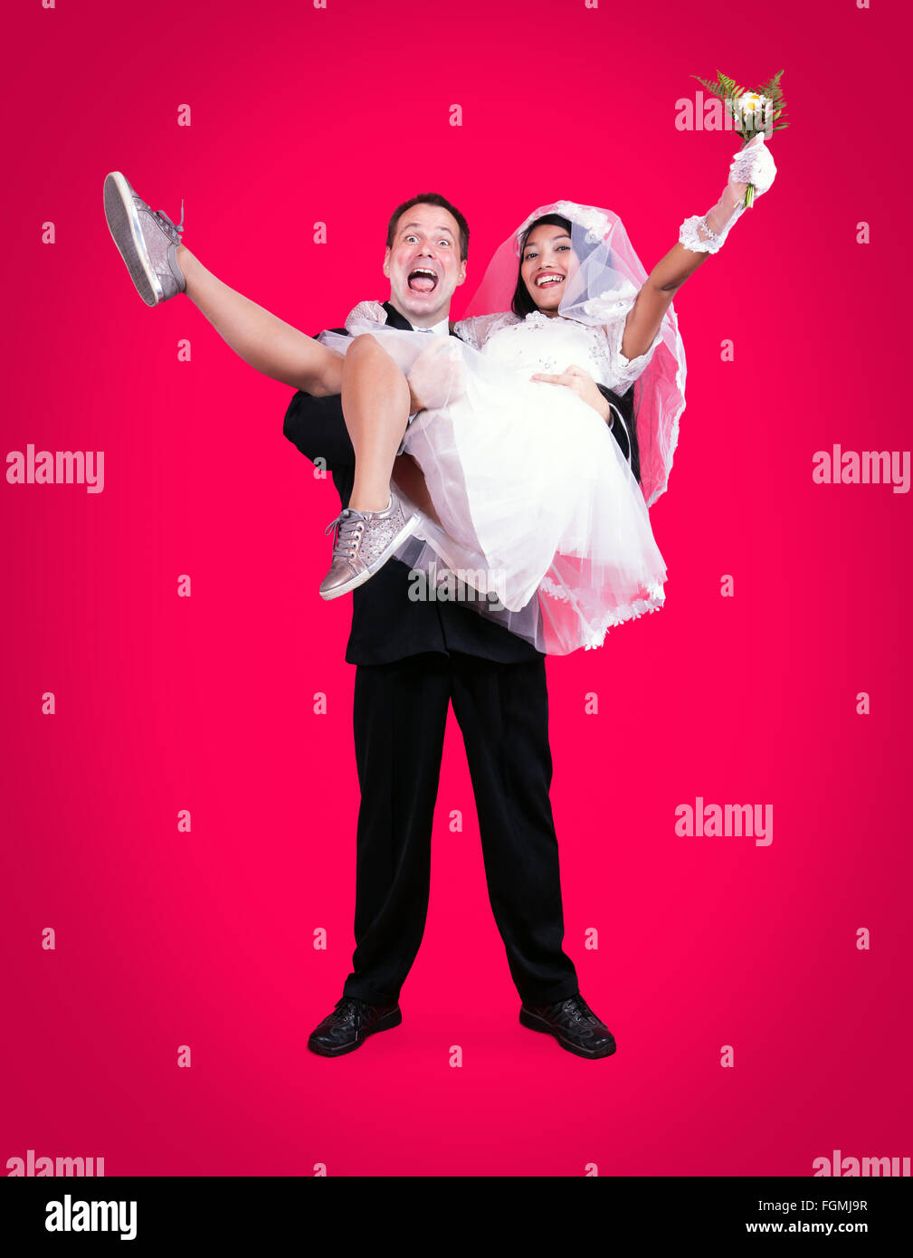 Happy groom holding the bride in his arms Stock Photo - Alamy