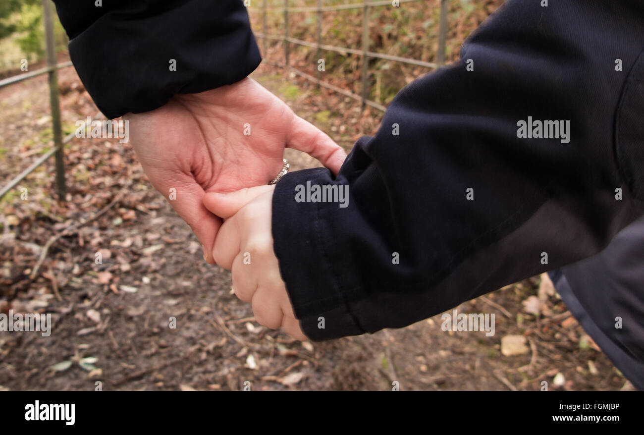 A mother guiding her son holding hands Stock Photo - Alamy