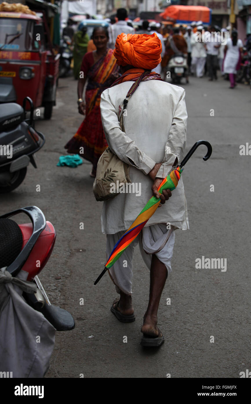 Pune, India - July 11, 2015: An old warkari walking down the road ...